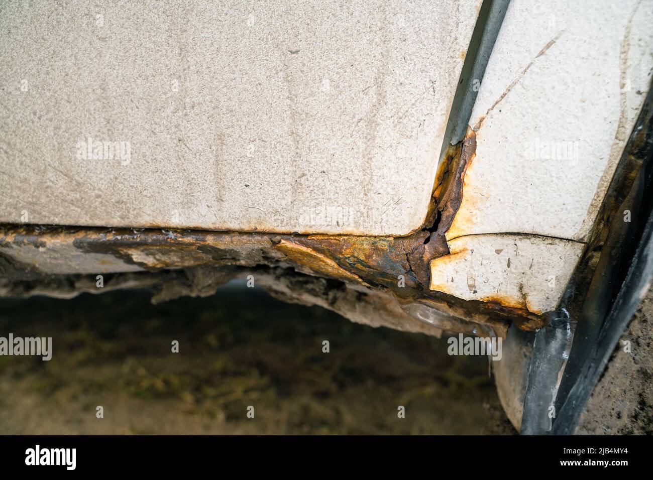 Rusted white car sills close-up. The effect of reagents in winter on an ...
