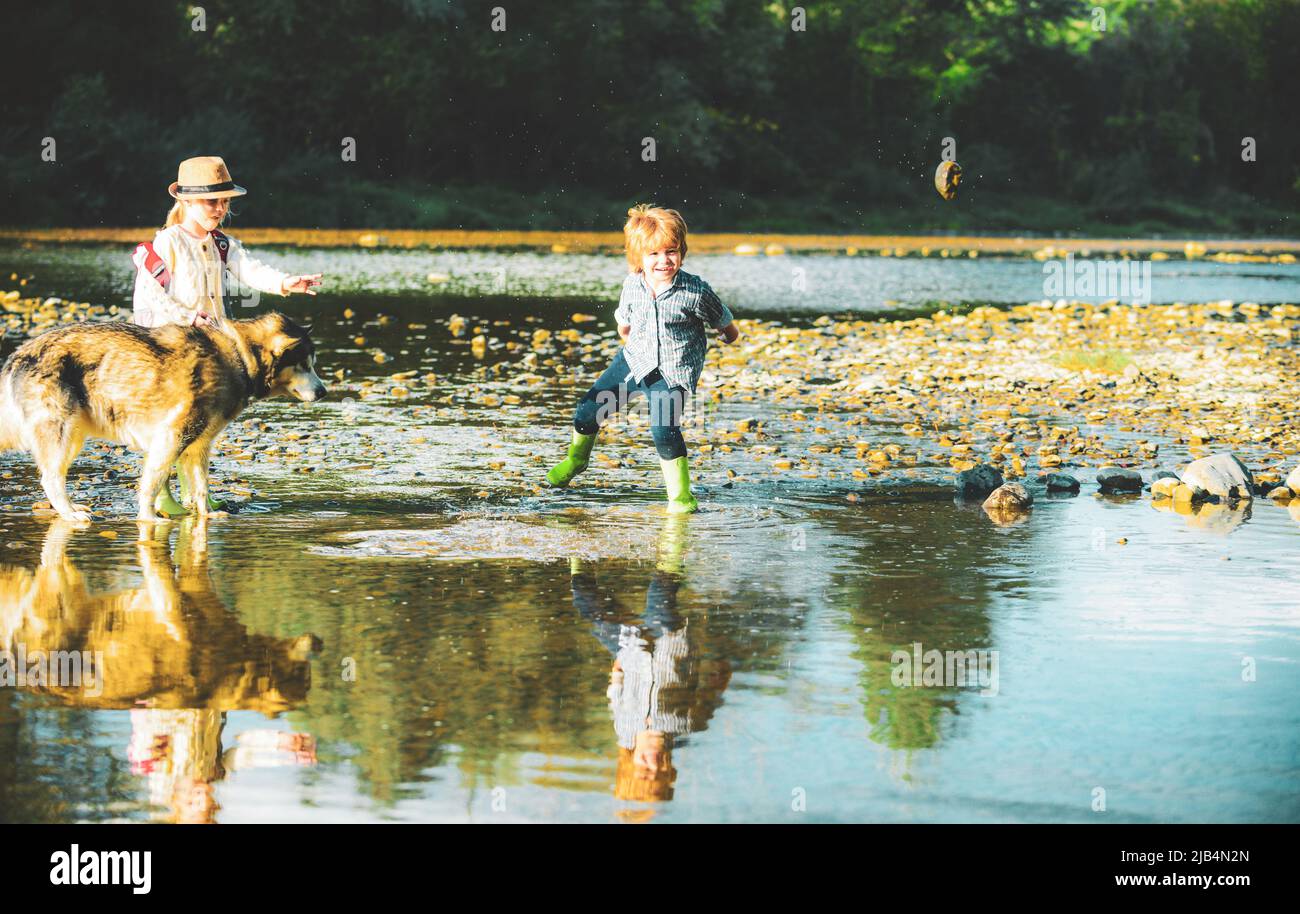 Stony river. Little boy and girl playing in the river. children throw ...
