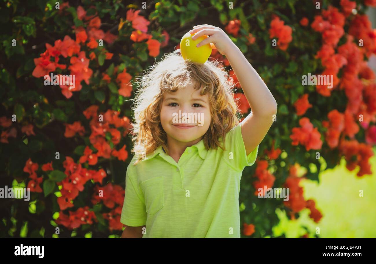 Little child with red apple on head outdoor Stock Photo - Alamy