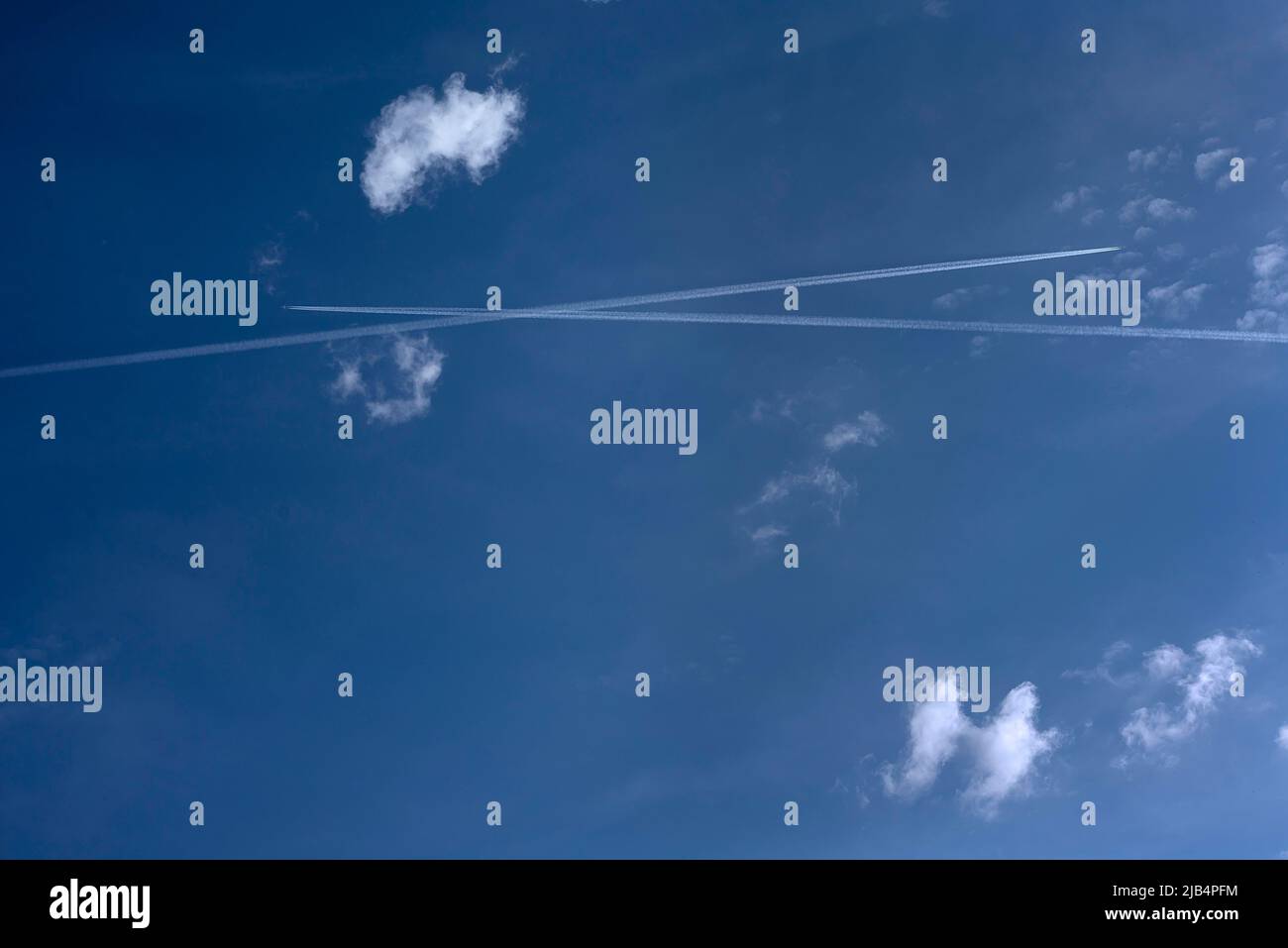 Crossing commercial aircraft with contrails, blue sky, Bavaria, Germany ...