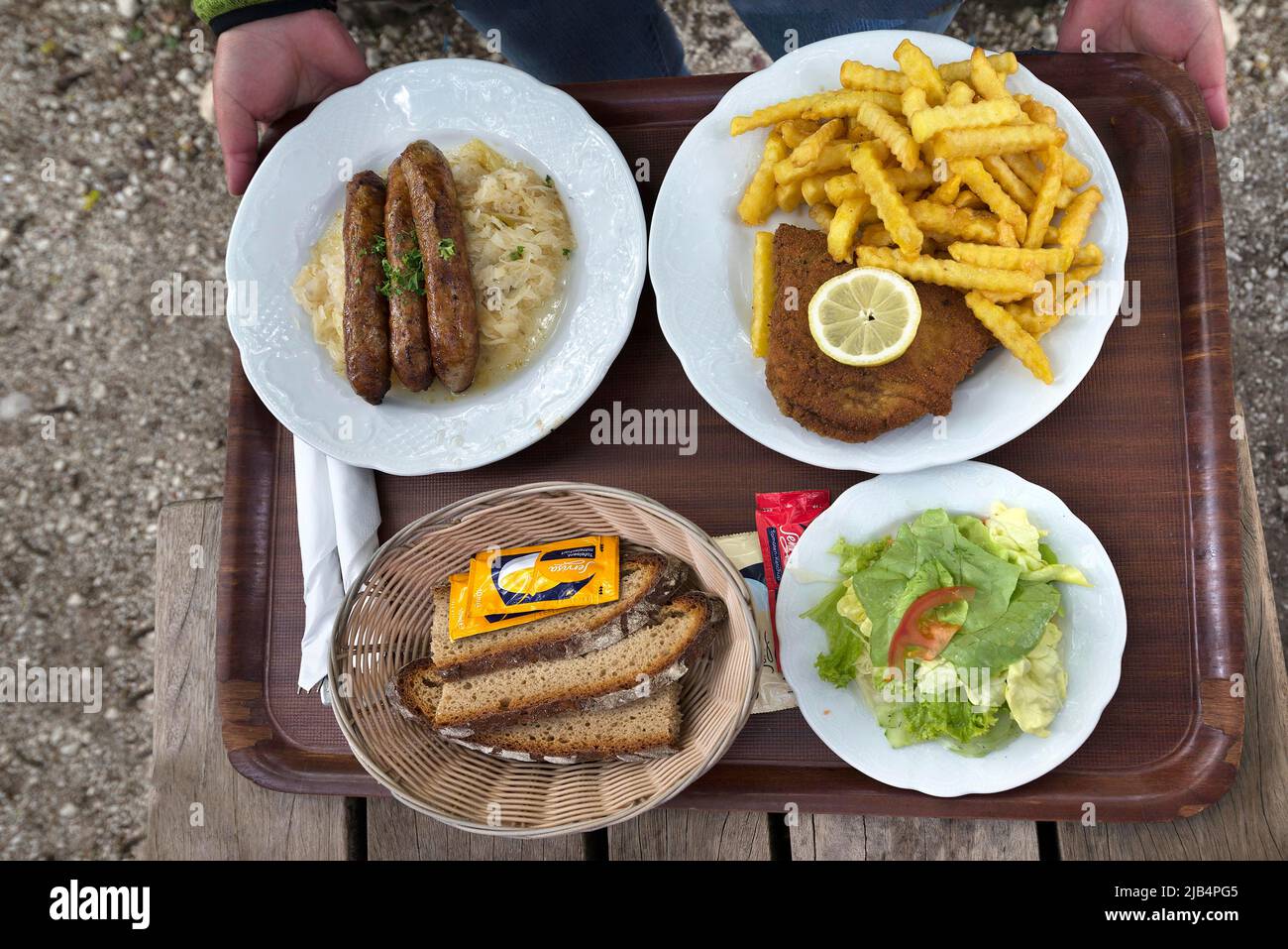Bratwurst with sauerkraut and bread and cordon bleu with chips served ...
