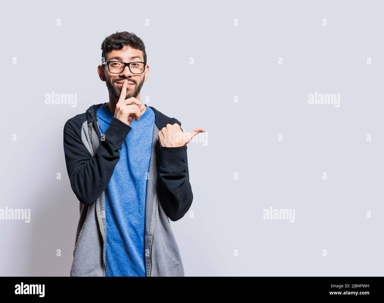 Mysterious person pointing to the side with his fingers on isolated ...