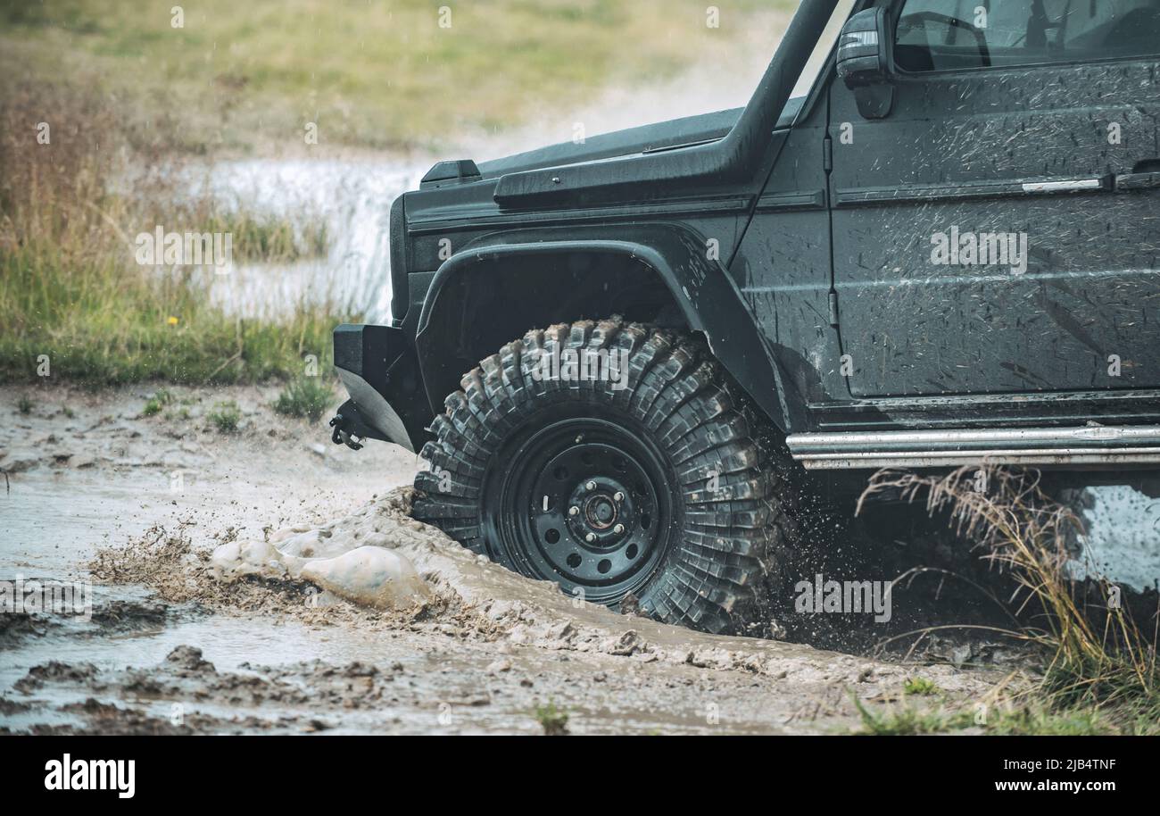 Off-road Jeep car on bad gravel road. Mud and water splash in offroad ...