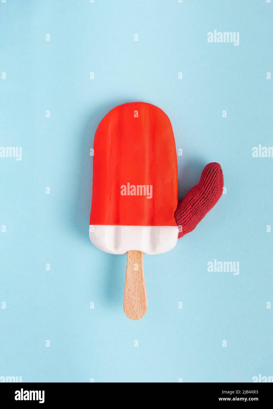 Red and white ice cream on a stick with thumb up on the blue background ...