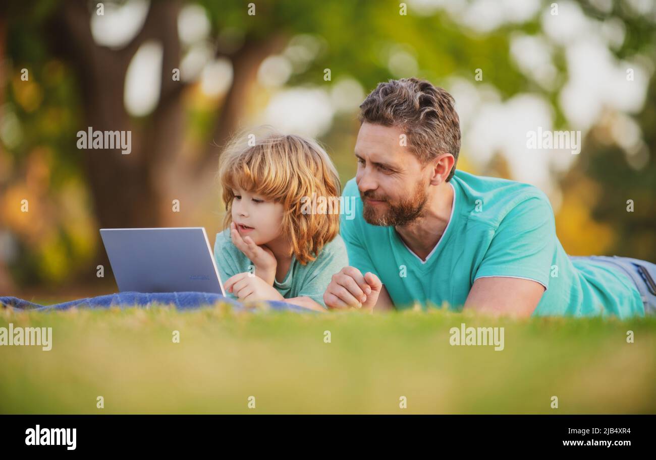 Father and son school boy with laptop. Dad and child use notebook ...