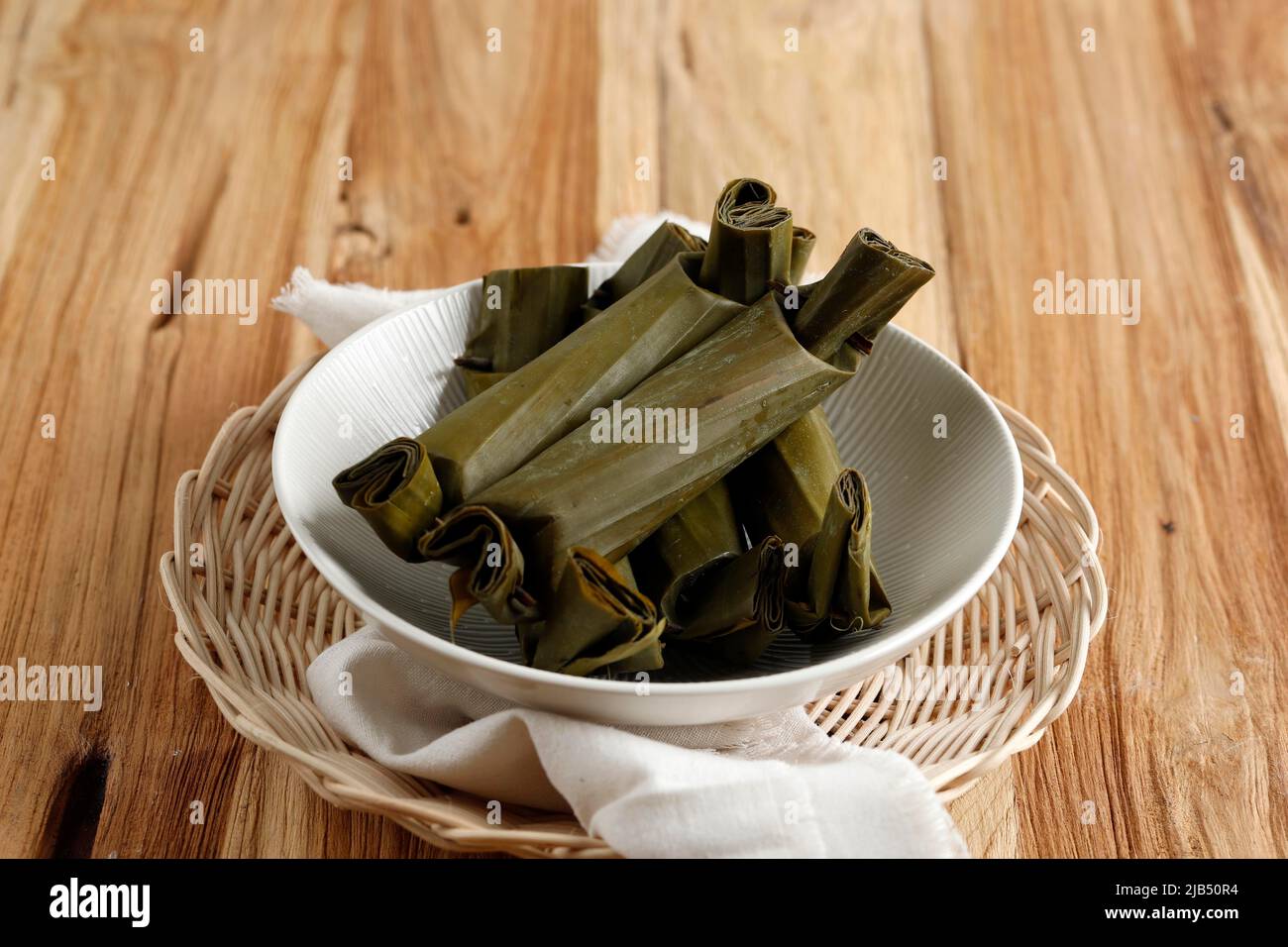 Lontong is an Indonesian dish. Rice is rolled inside a banana leaf and ...