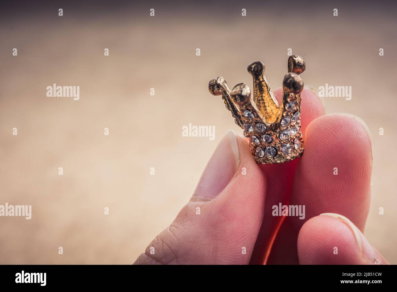 Hand holding a little model crown in hand Stock Photo - Alamy