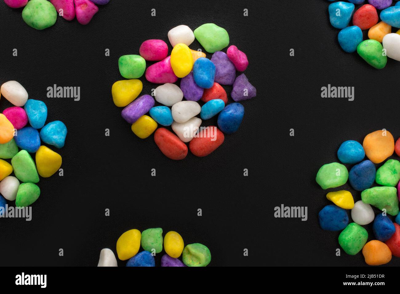 Pile of little colorful pebbles on black background Stock Photo - Alamy