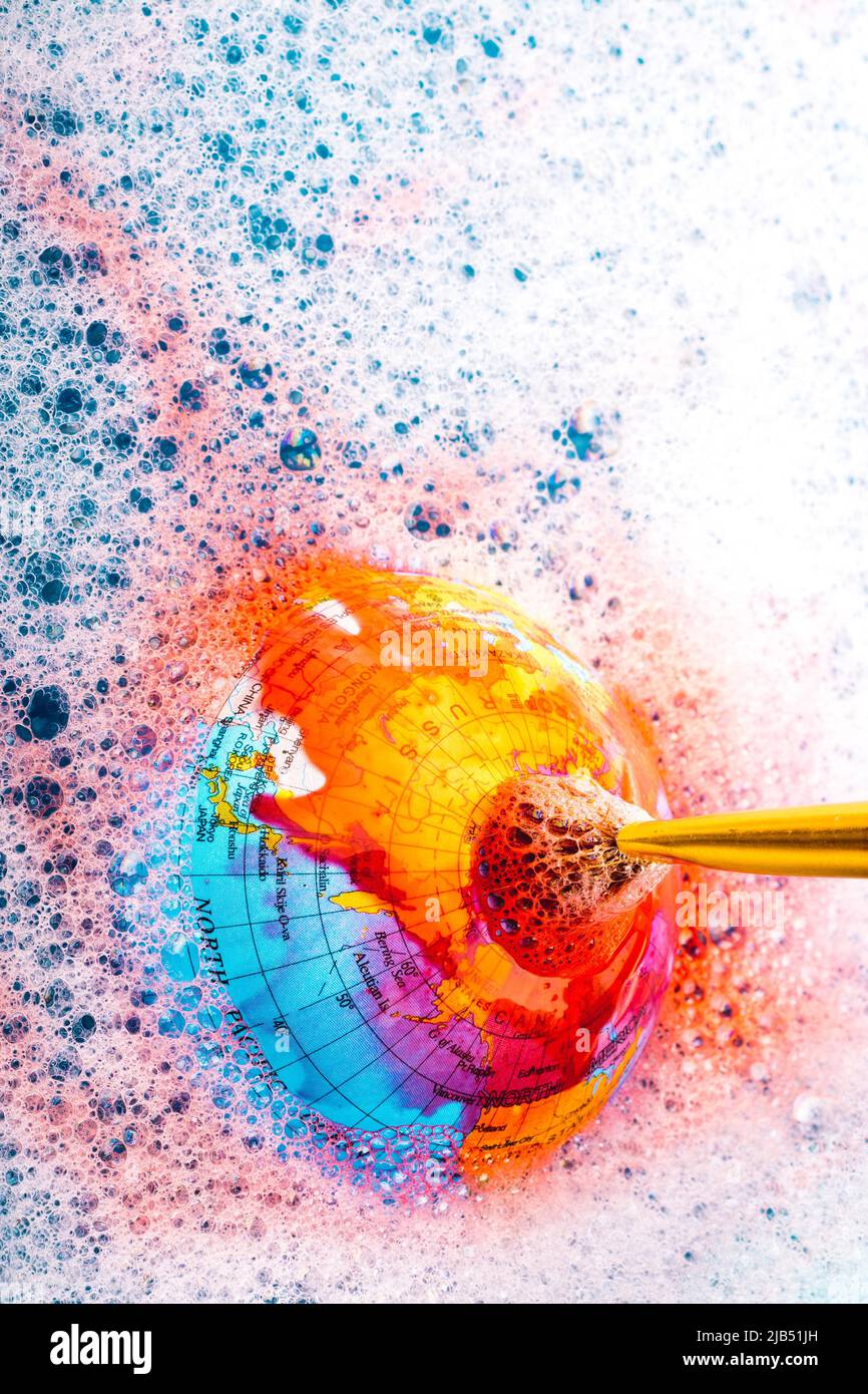 Paint dissolving through painting brush on the top of globe Stock Photo ...