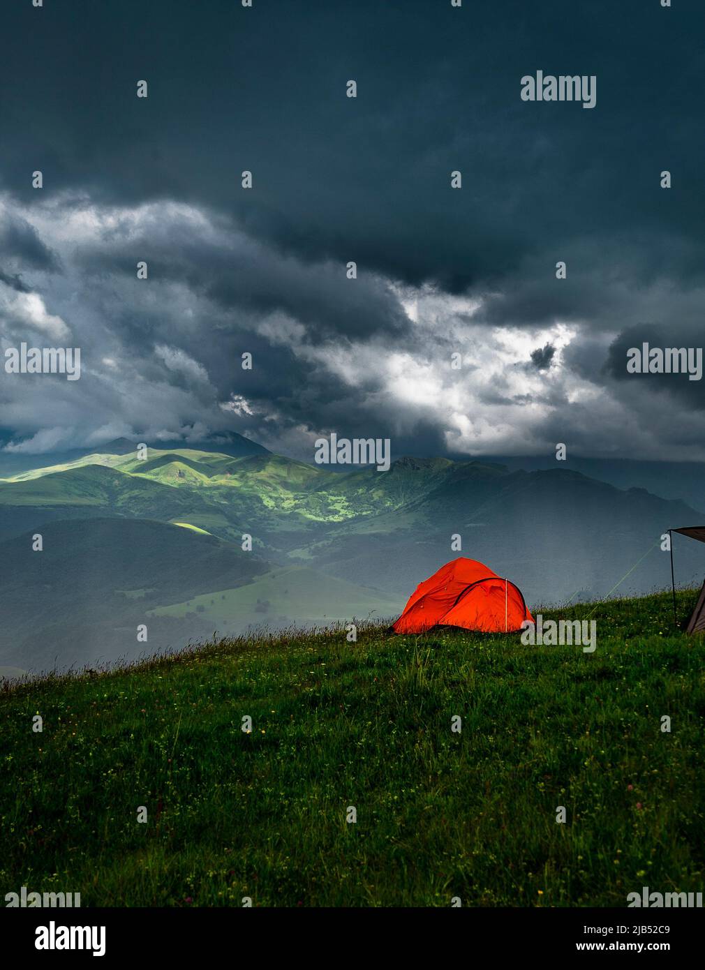Camping in the mountains with tent standing on a hill, night and sunset ...