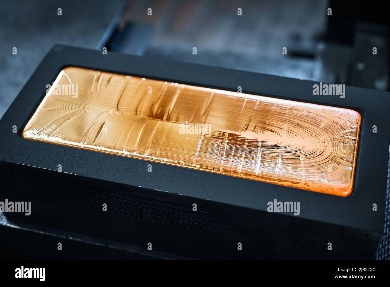 Gold ingot in graphite casting form on workbench at plant Stock Photo ...