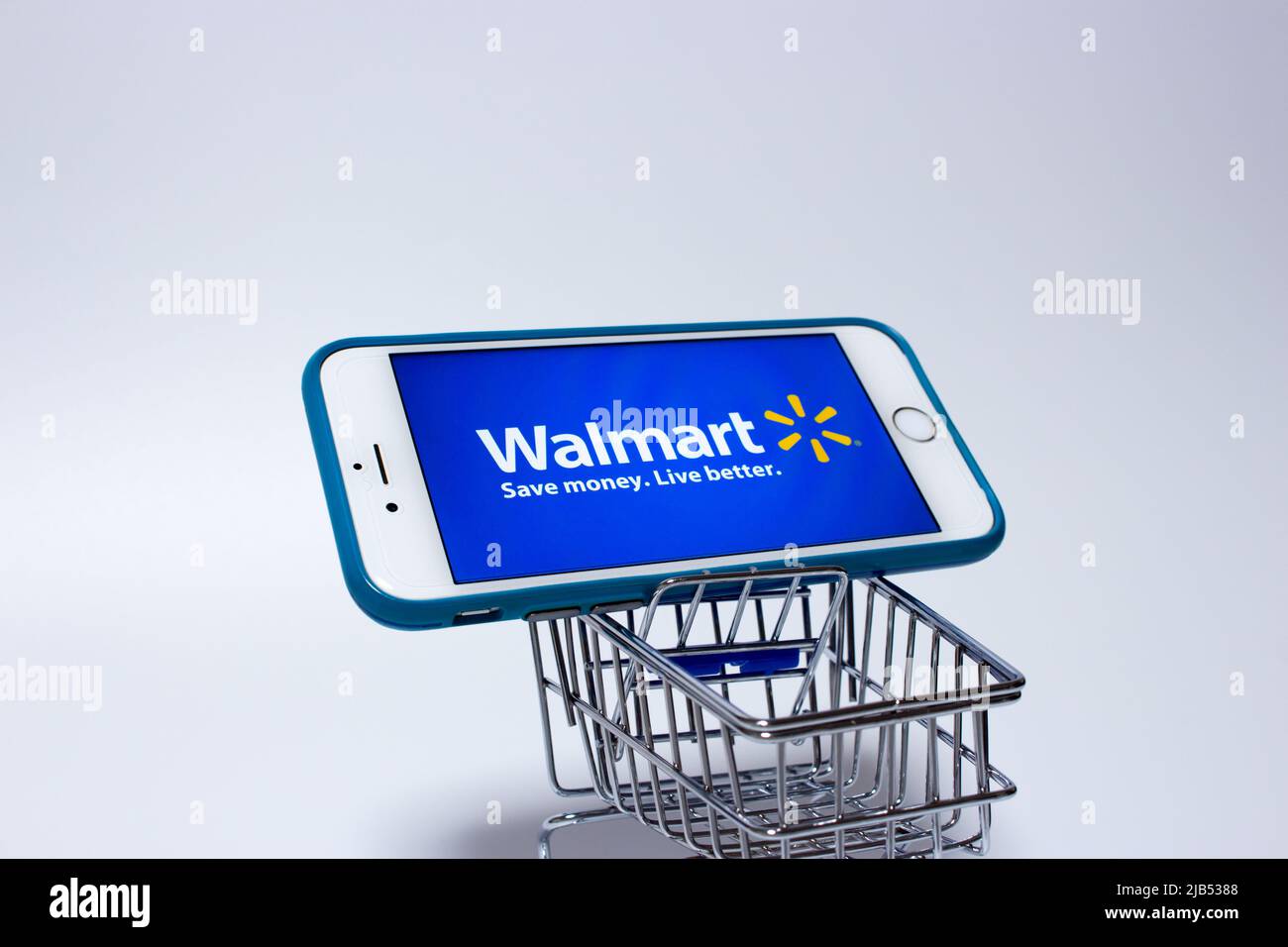 Walmart Logo on iPhone in a shopping cart. Walmart Inc. is an US retail ...