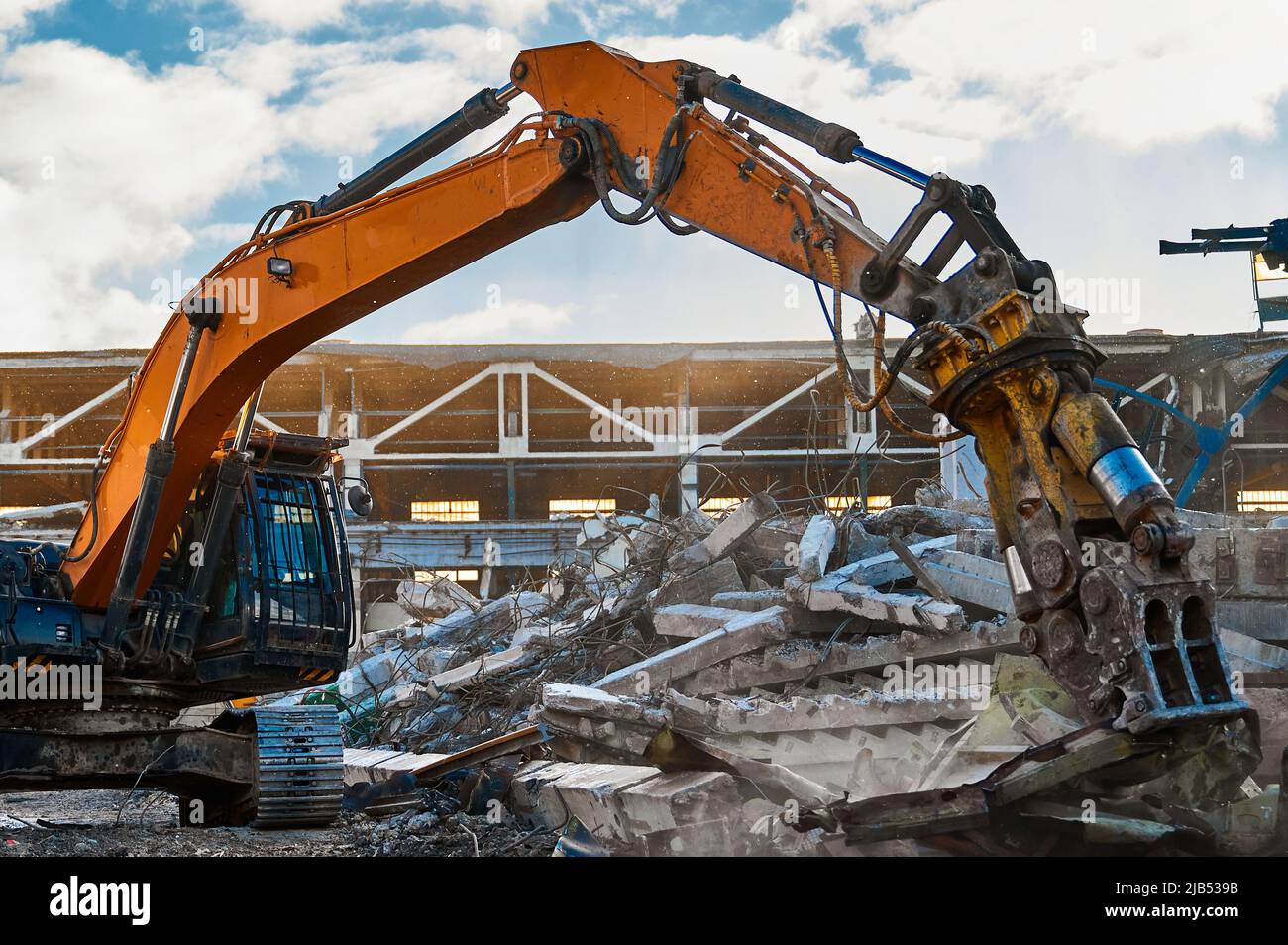 Excavator with hydraulic scissors cuts concrete beams Stock Photo - Alamy