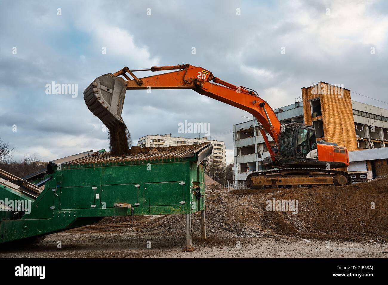 Excavator loads soil in mobile crushing and sorting complex Stock Photo ...