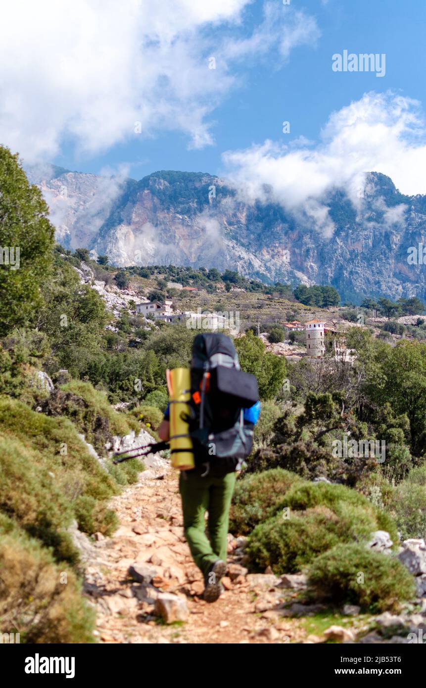 A tourist with a backpack moves along the Lycian trail. Cloudy ...