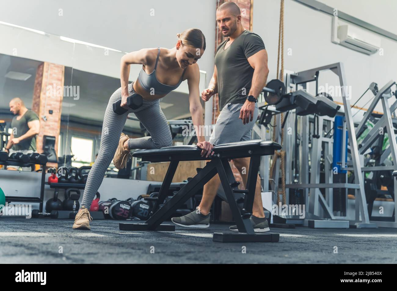 An attractive caucasian young adult woman using free weights at a ...