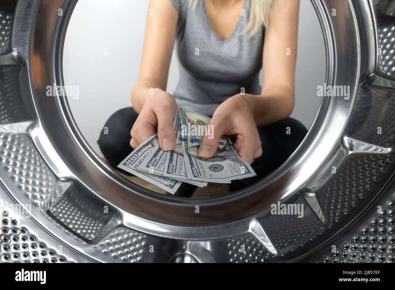 Women's hands hold money near the washing machine, a photo from inside ...