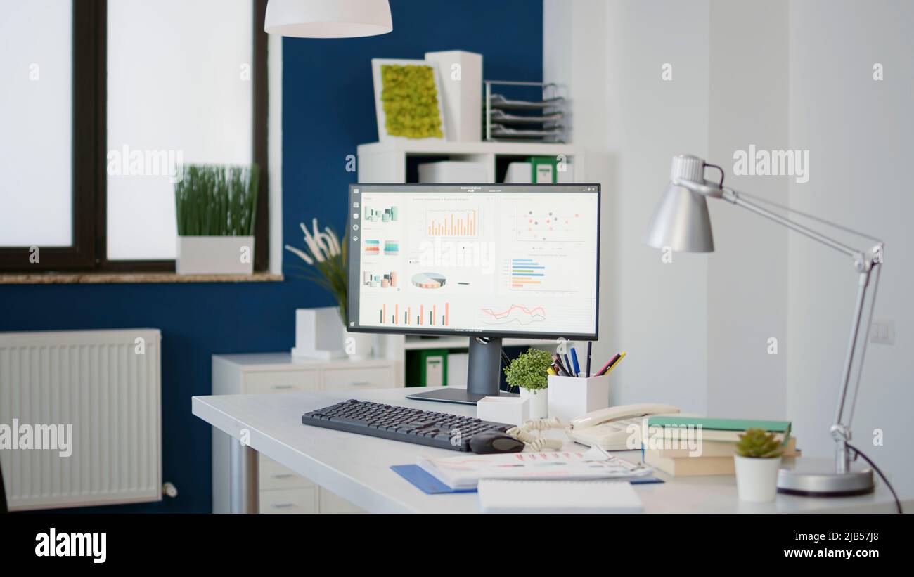 Empty desk with computer monitor showing financial statistics charts on ...