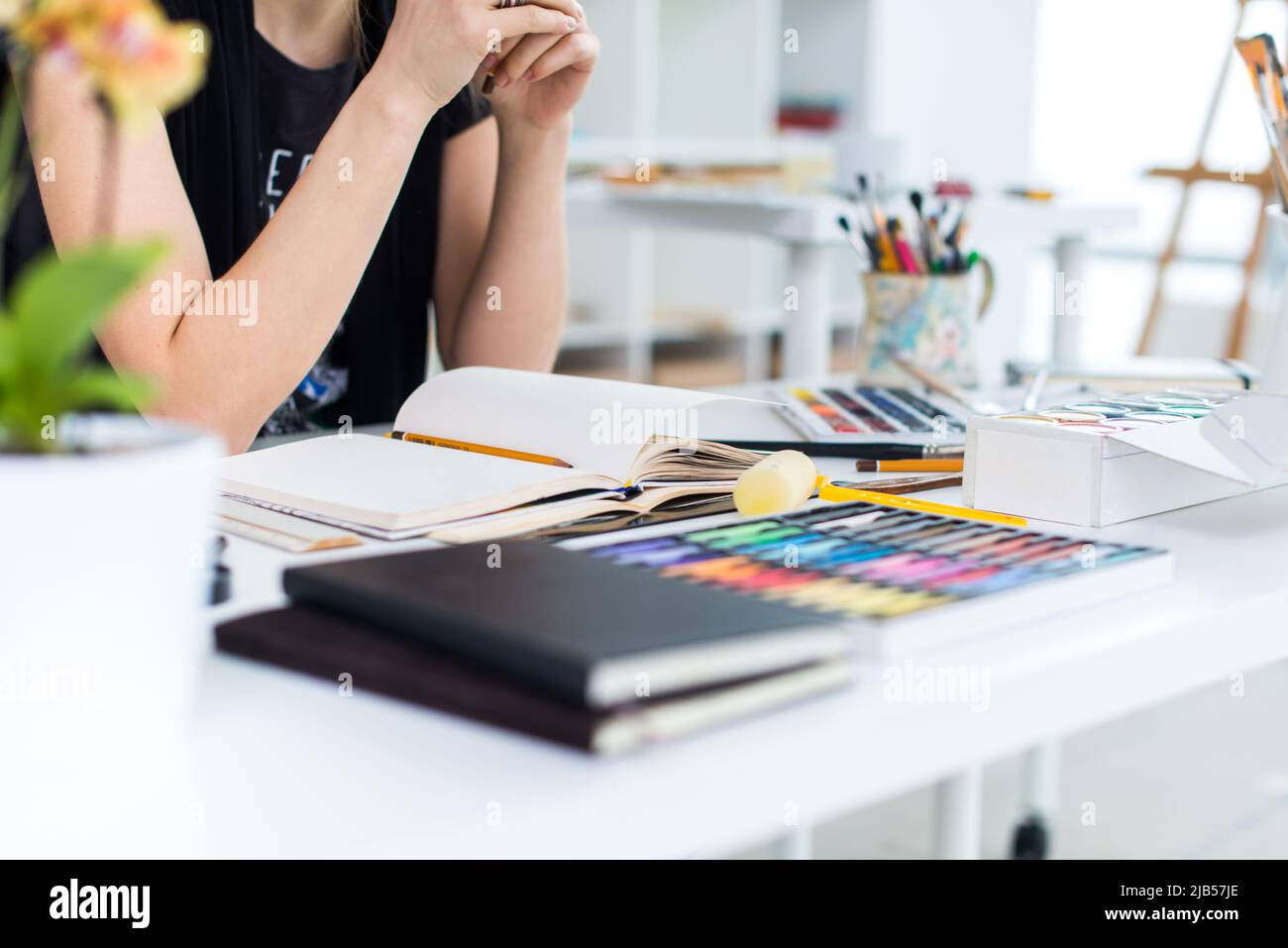 Close-up angle view of a female painter drawing draft at sketchbook ...
