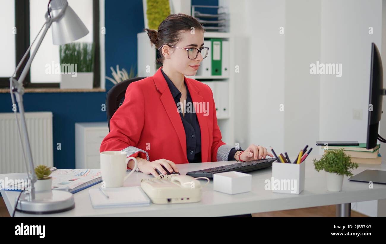 Company assistant planning business strategy on computer, using sales ...