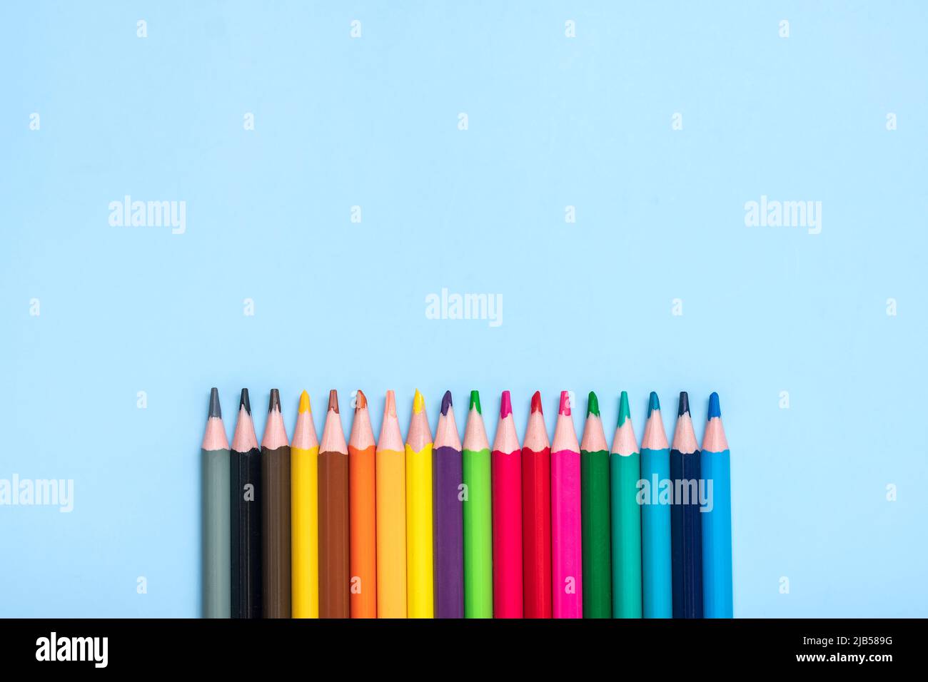 set of colored pencils isolated on blue background Top view Flat lay ...