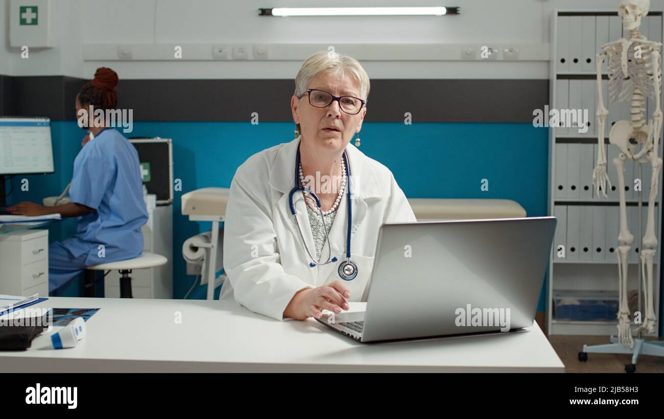 Portrait of general practitioner using laptop at health care checkup ...