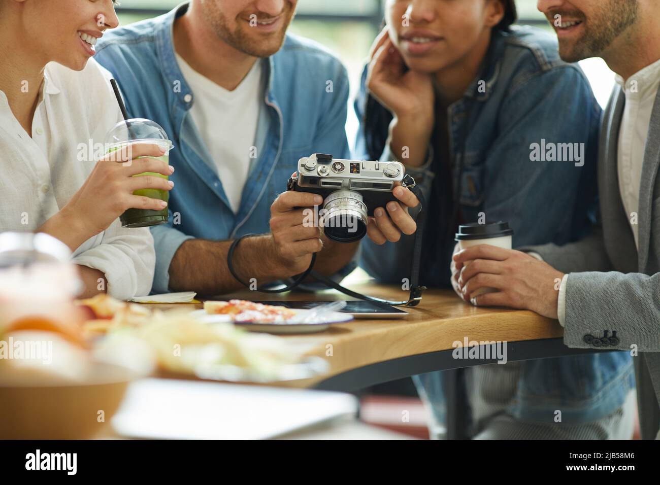Close-up of positive young multi-ethnic friends leaning on counter in ...