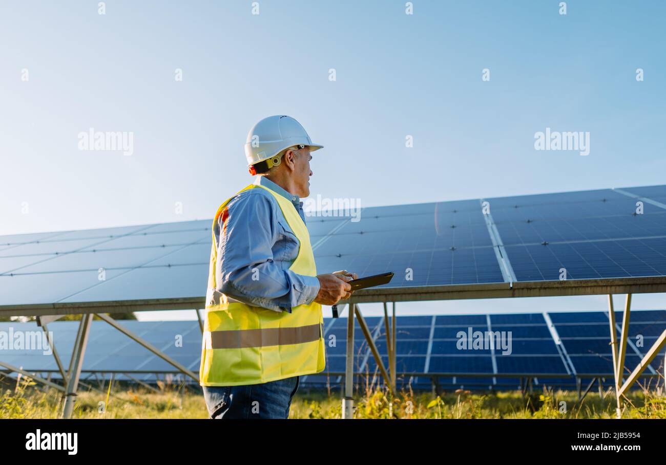 Worker checking solar panels with tablet in solar farm. Eco energy ...