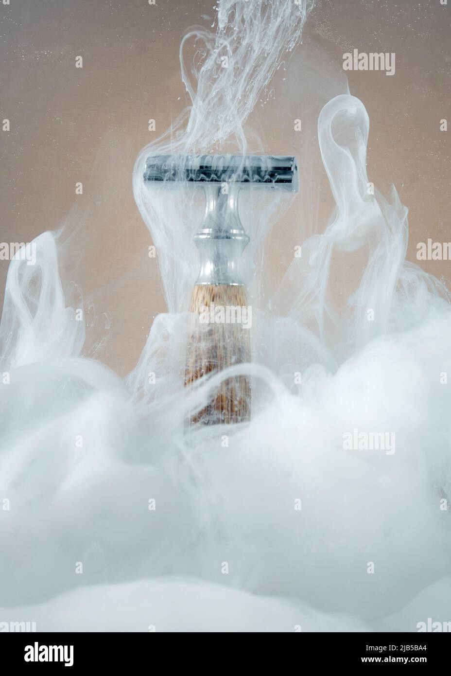 safety razor in water surrounded with dramatic white cloud of ink on ...