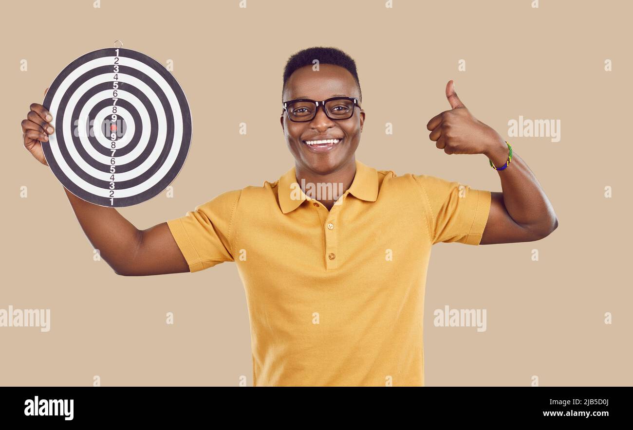 Happy African American man showing shooting target, smiling and giving ...