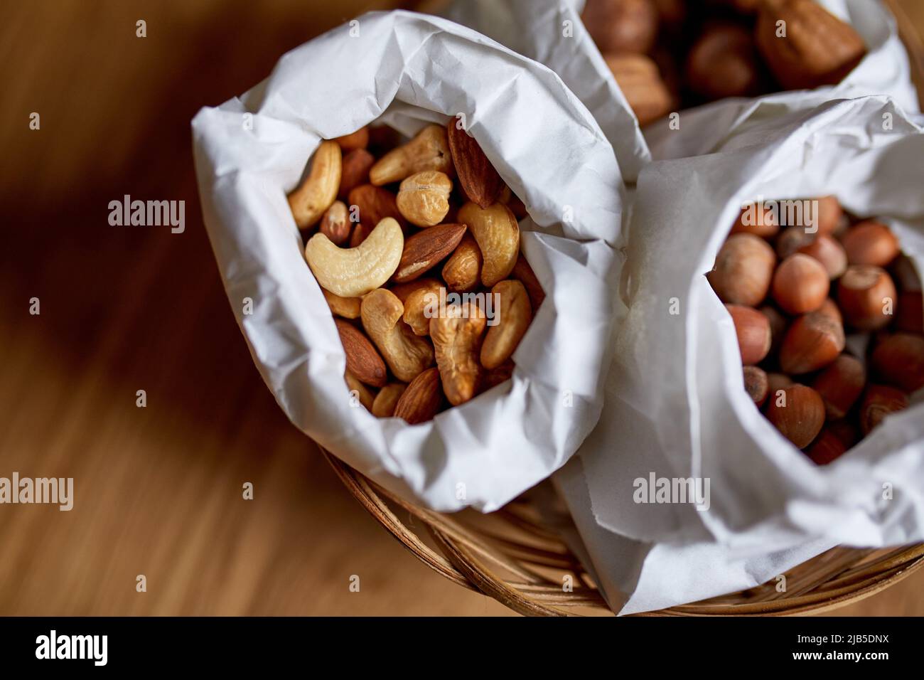 Top view Various sort of nuts on the table in a paper bag on wooden ...