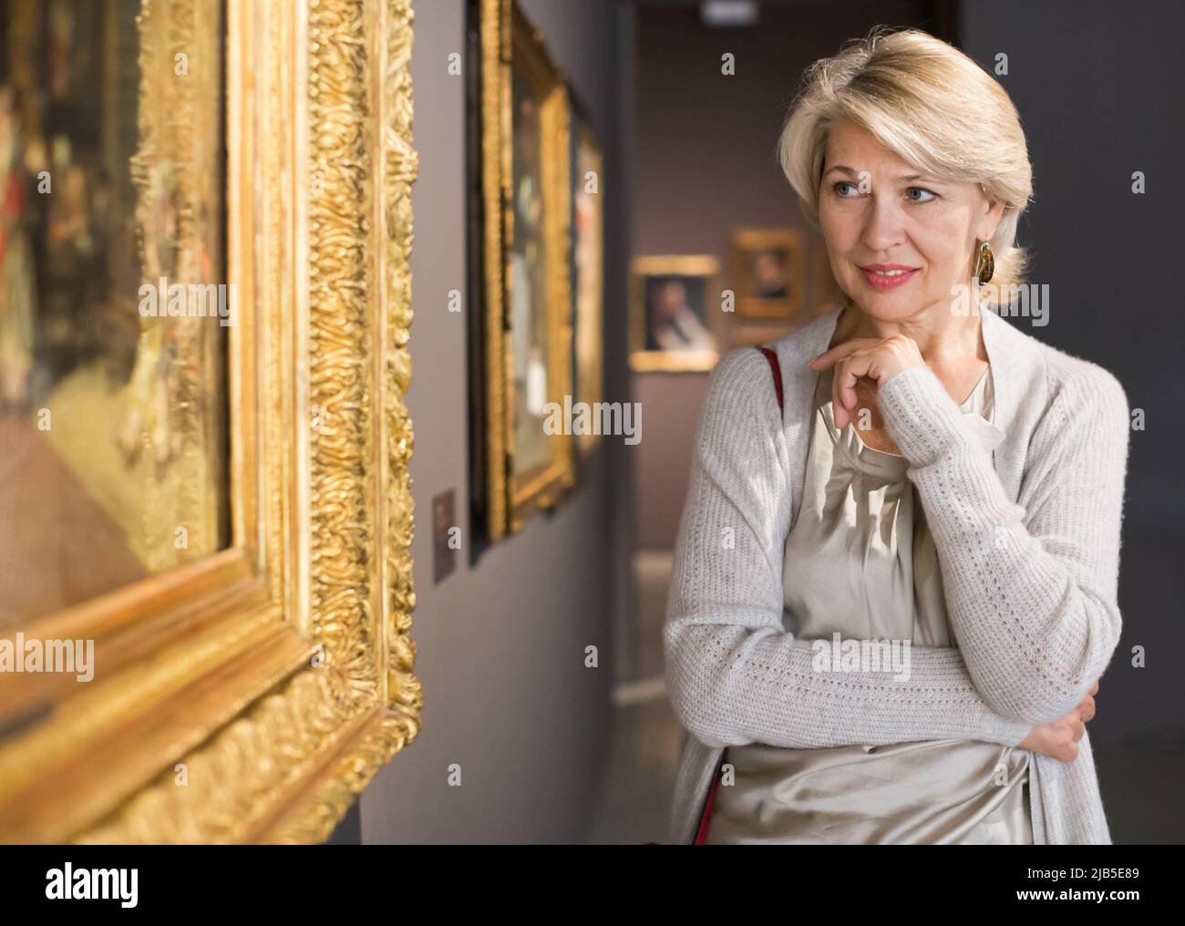 Mature woman in art museum near the painting Stock Photo - Alamy