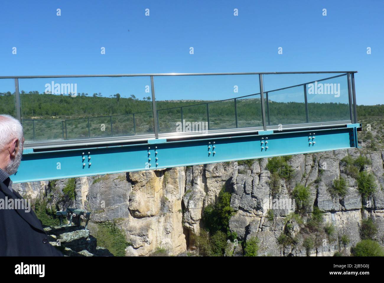 Man in Dark Suit on Glass Platform Overlooking Scenic Cliffs and ...