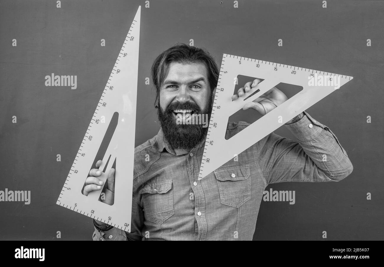 measure and size. happy mature teacher holding triangle tool. bearded ...