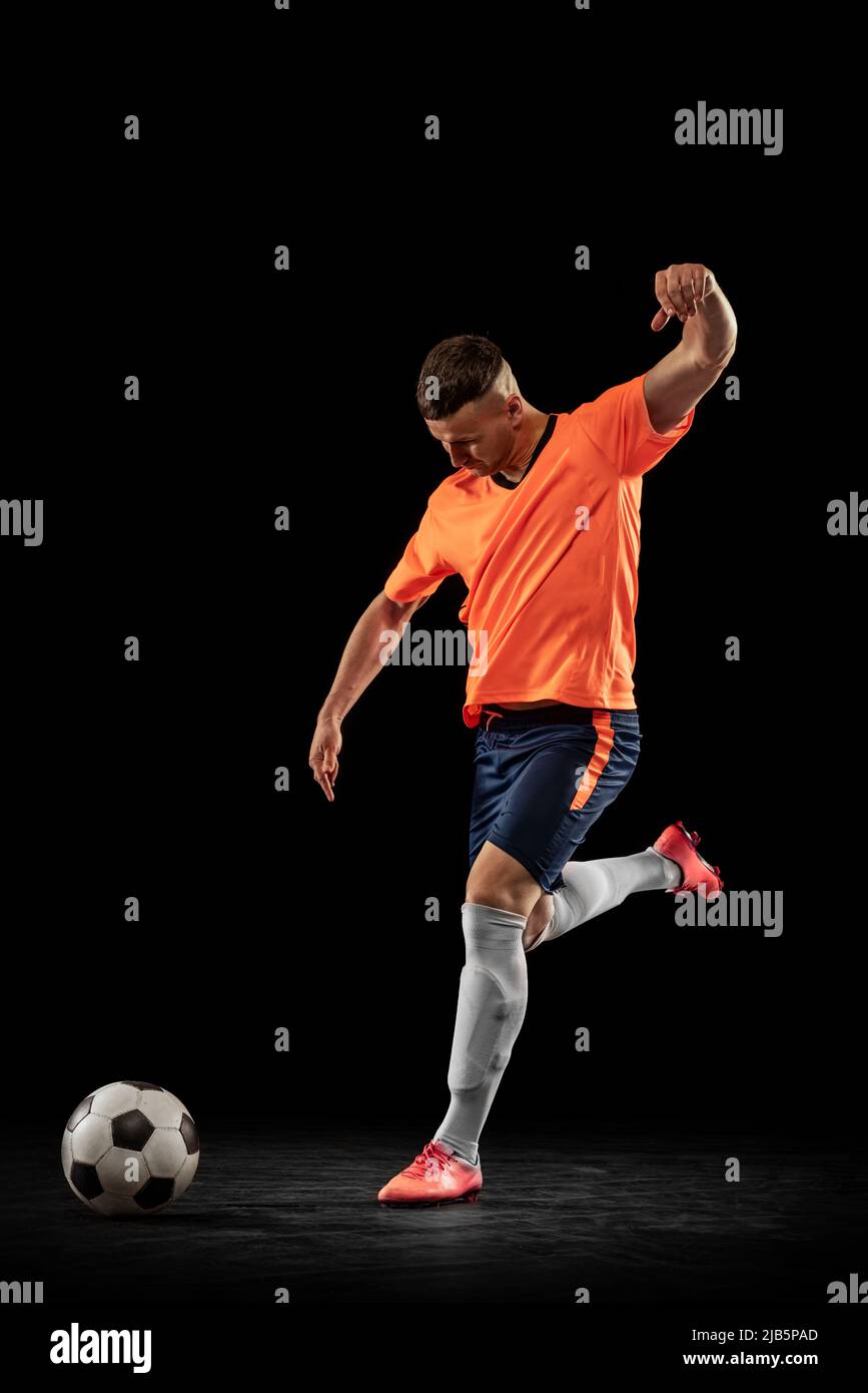 Studio shot of professional male football soccer player in motion ...