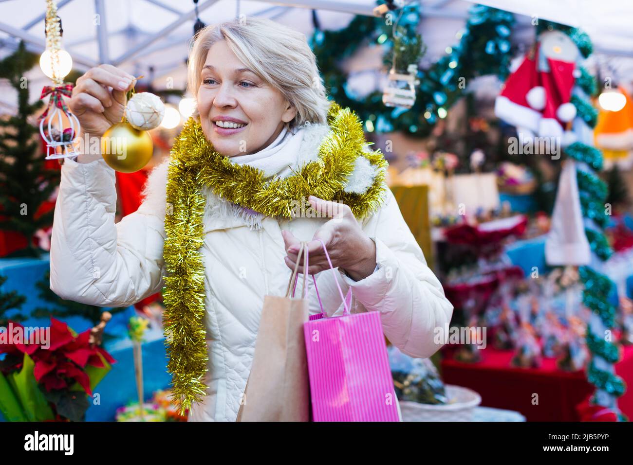 Woman is preparing for Christmas and choosing balls on the tree Stock ...