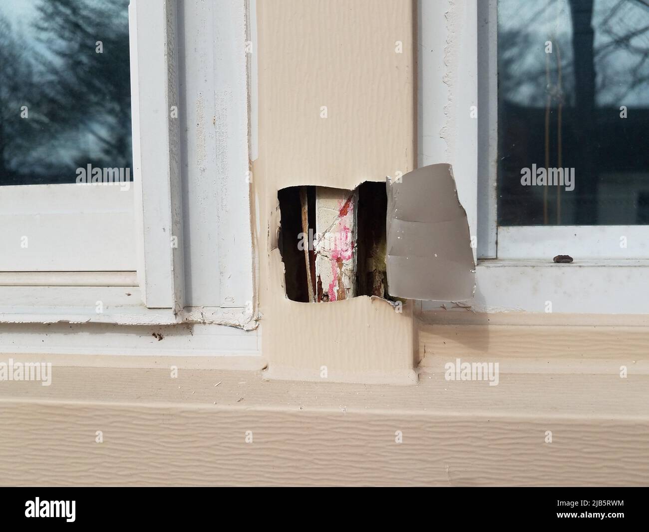 hole or damage in metal window frame on house Stock Photo - Alamy