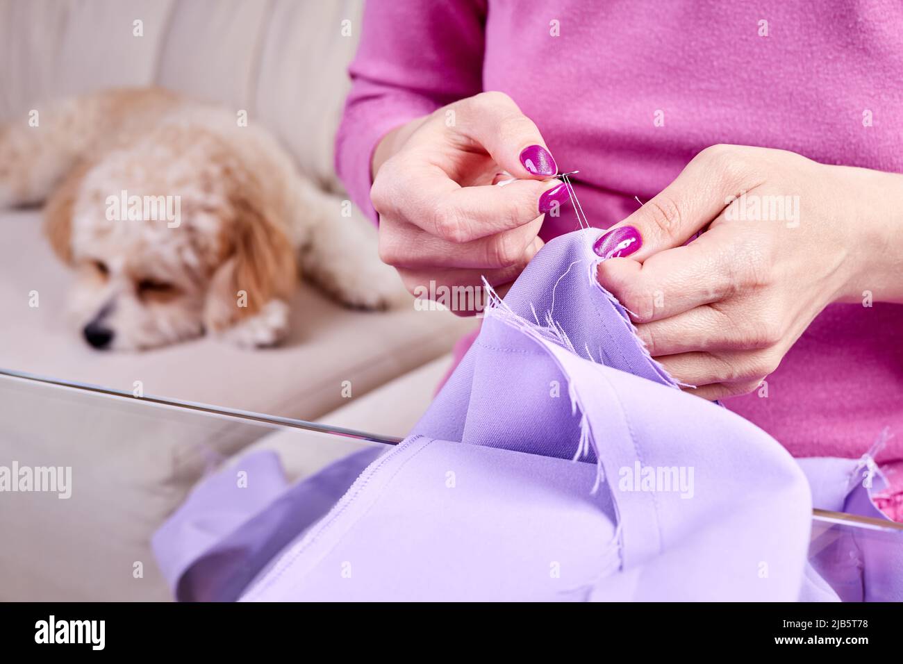 Close-up of the girl rips the seam on the dress using a seam ripper ...