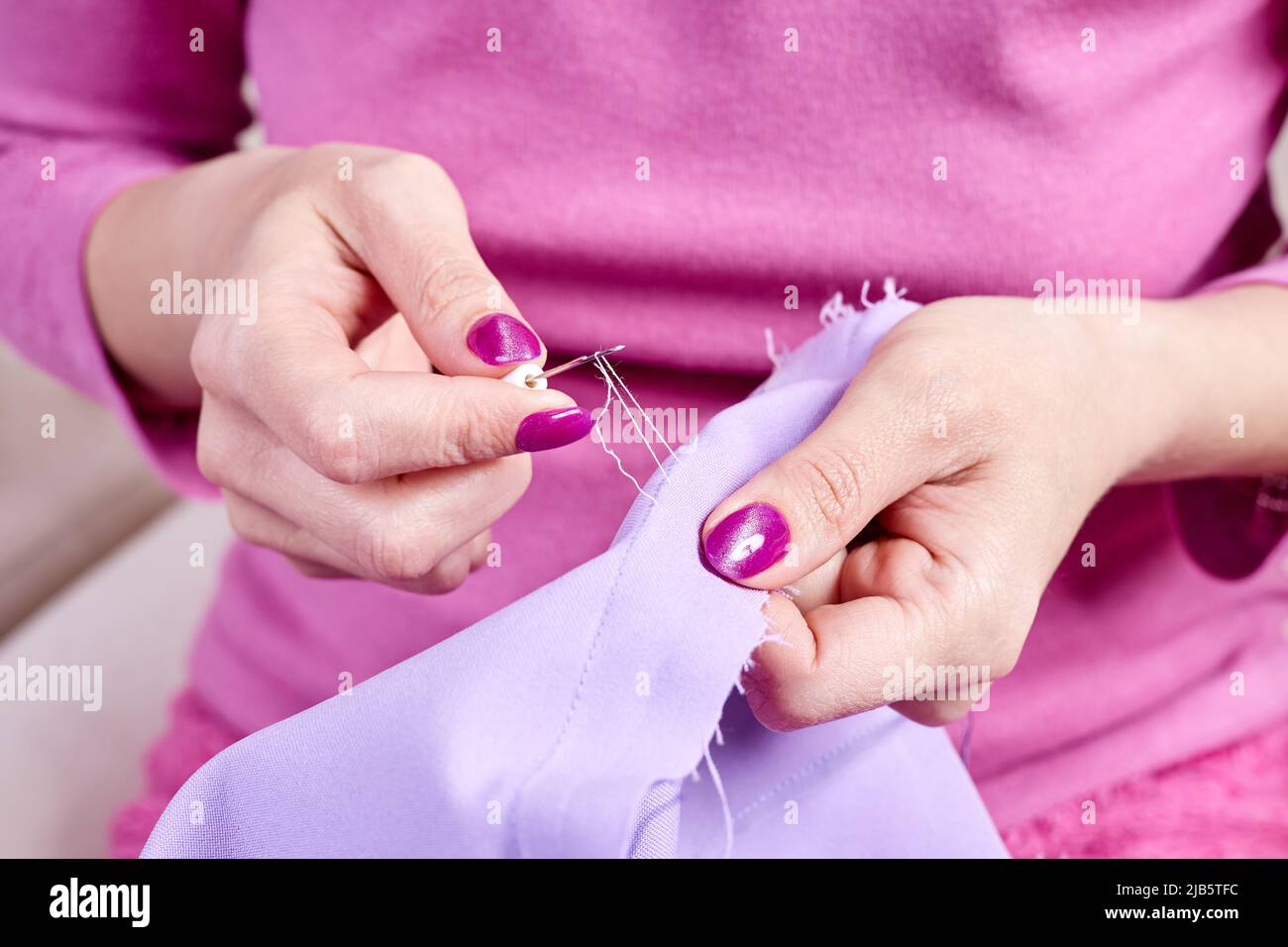 Close-up of the girl rips the seam on the dress using a seam ripper ...
