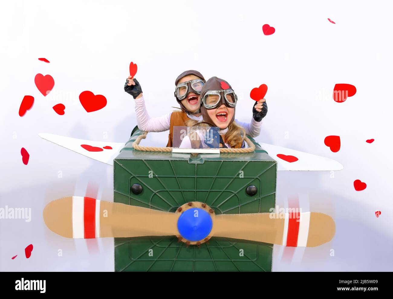 Twin sisters sit at the controls of their imaginary airplane. They are ...