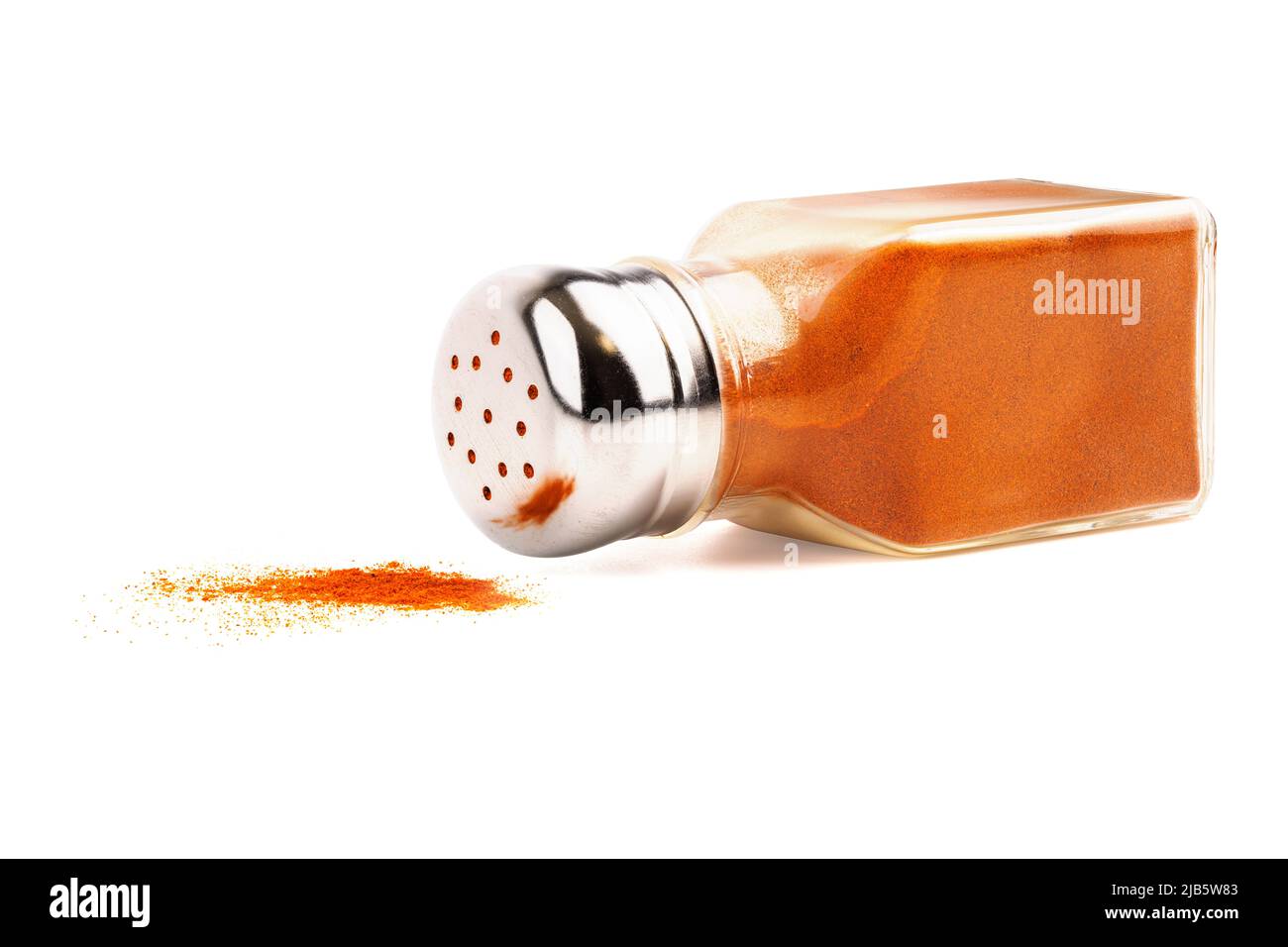 glass pepper pot with ground red pepper dropped on its side isolated on ...