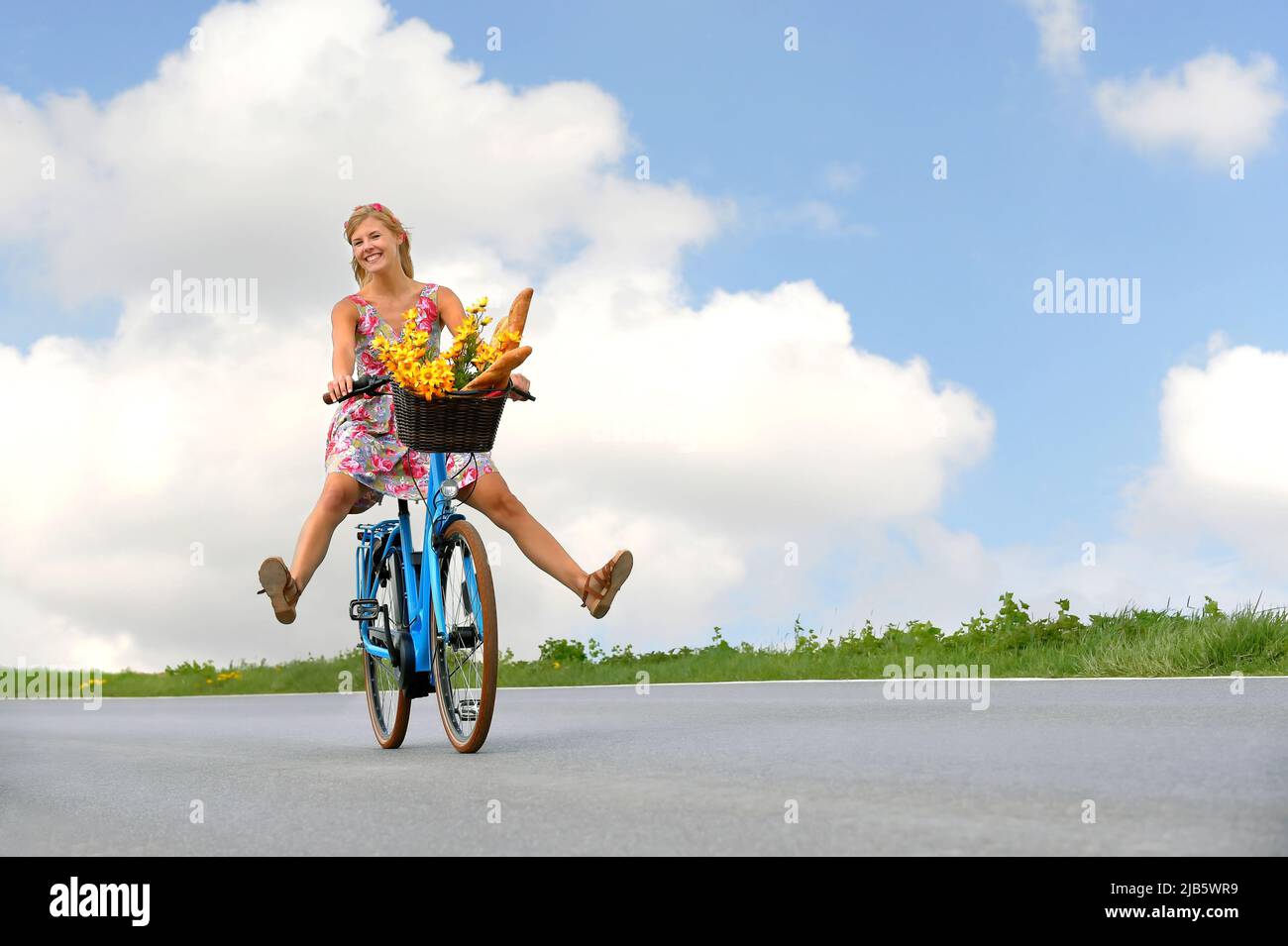 A carefree young woman enjoys her new electric hybrid bicycle. She ...