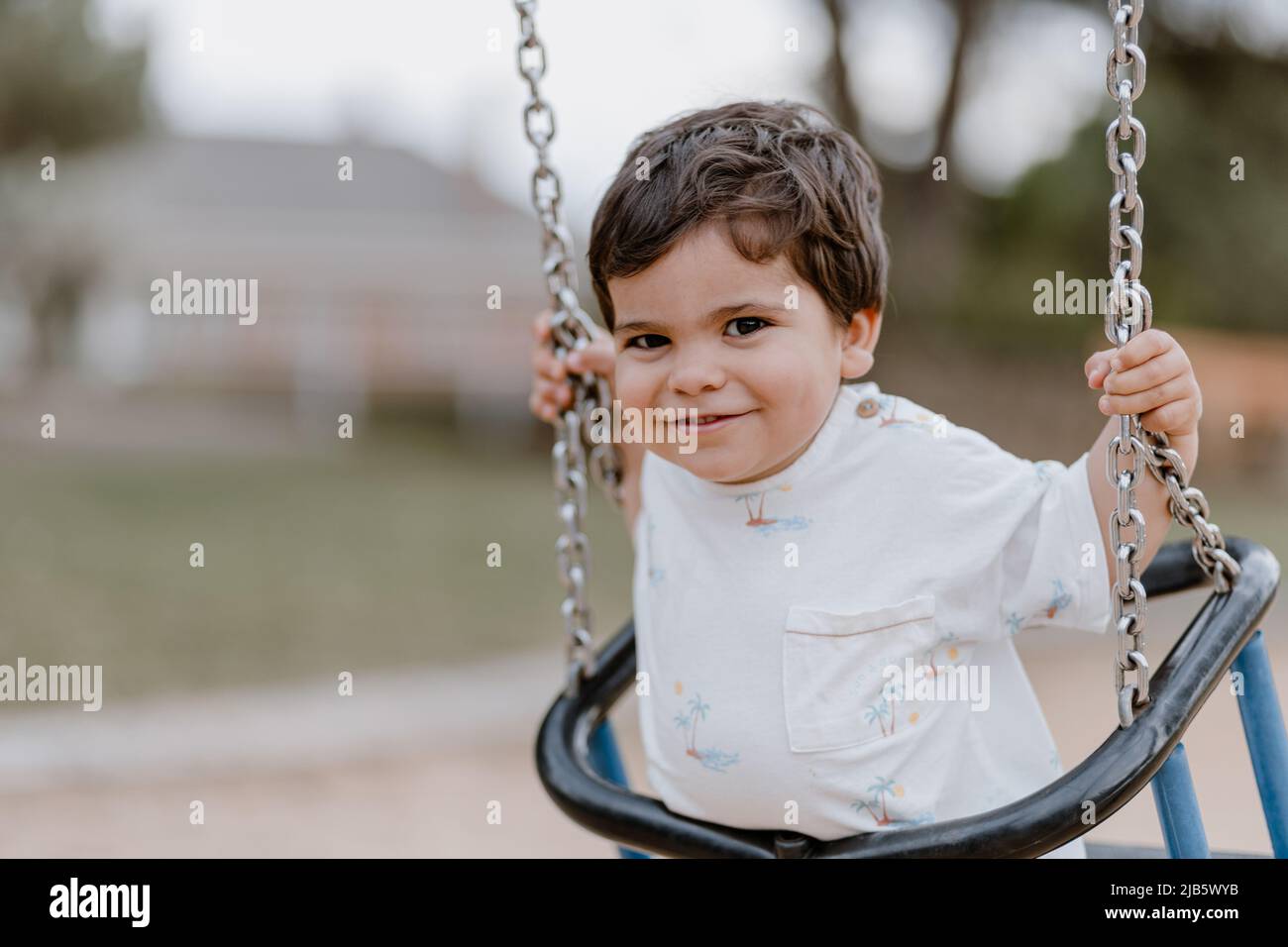 Little boy riding on a happy swing Stock Photo - Alamy