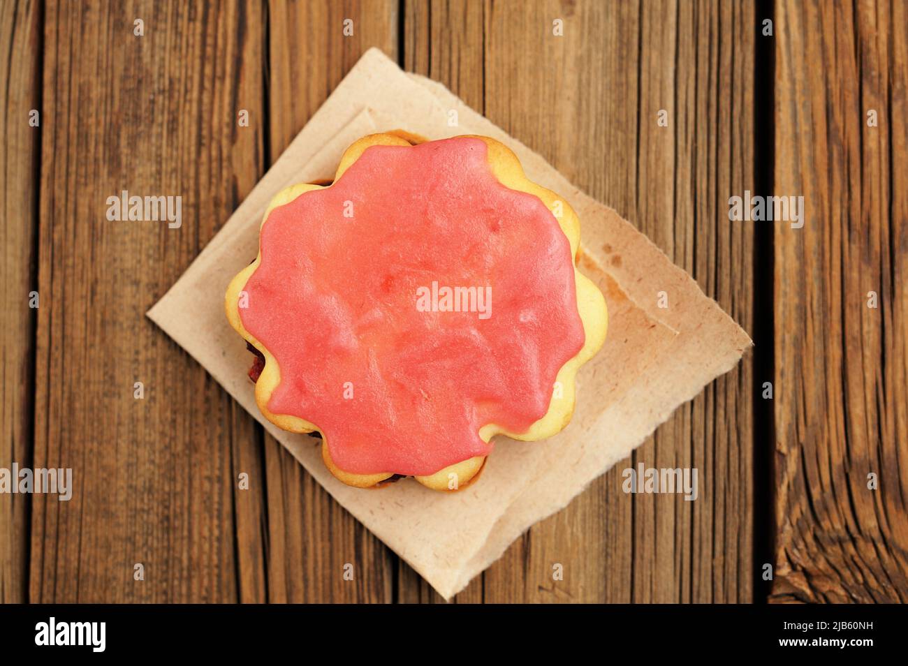 Russian shortbread cookie with pink icing on craft paper top view ...