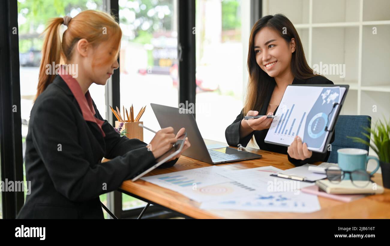 A confident asian female financial consultant presenting the business ...