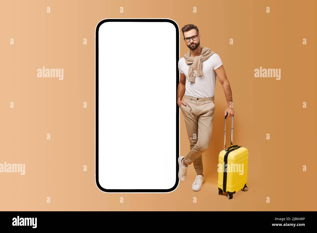 Travel app. Handsome charismatic bearded man stands with luggage near ...
