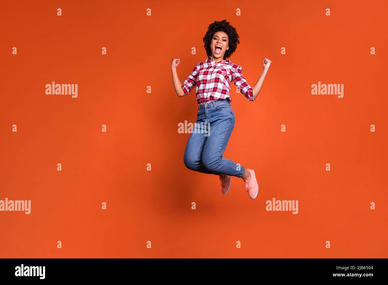 Full length photo of carefree positive lady jump high fist up scream ...
