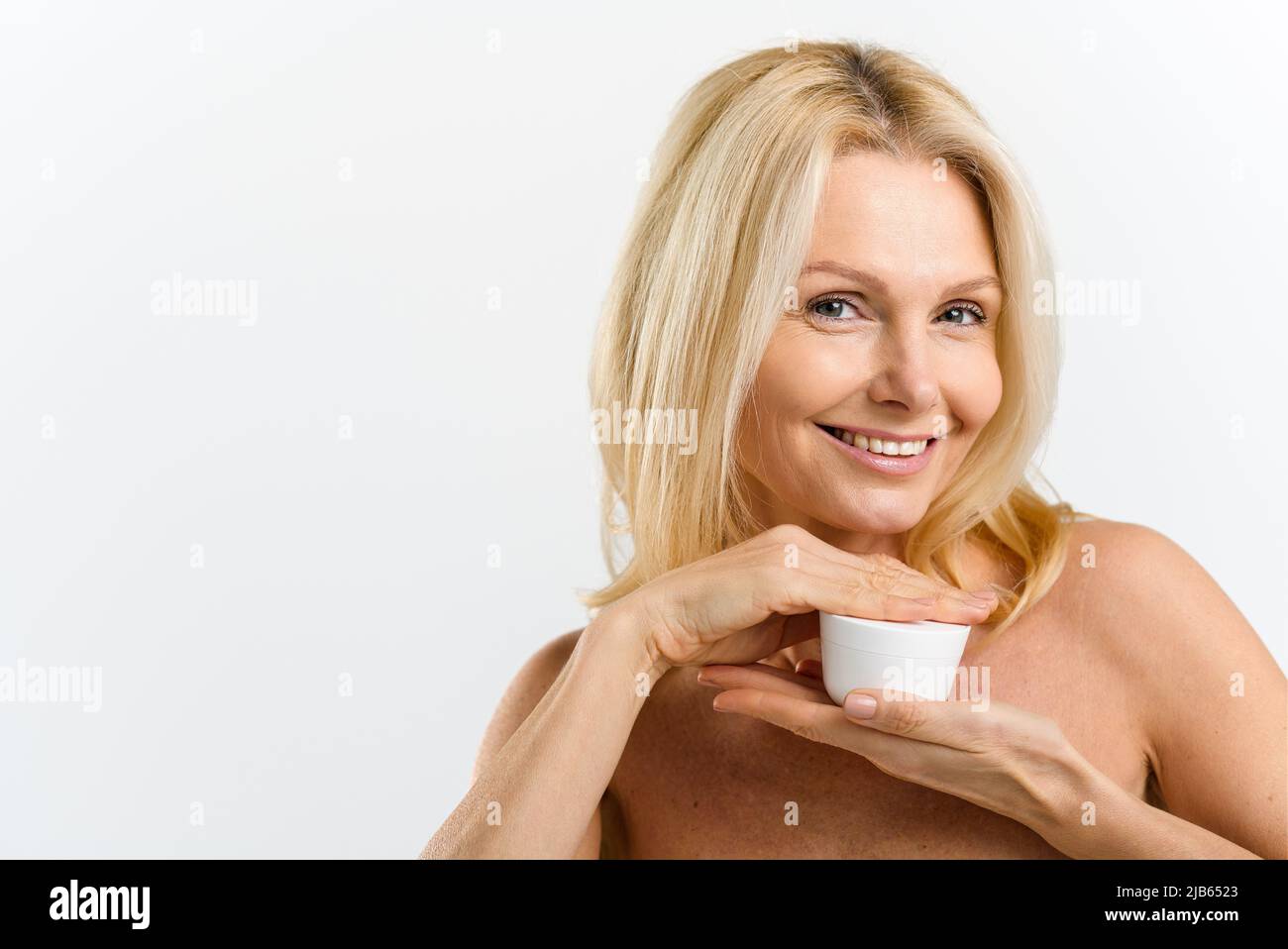 Middle Aged 50s Woman Holding Jar With Anti Aging Moisturiser