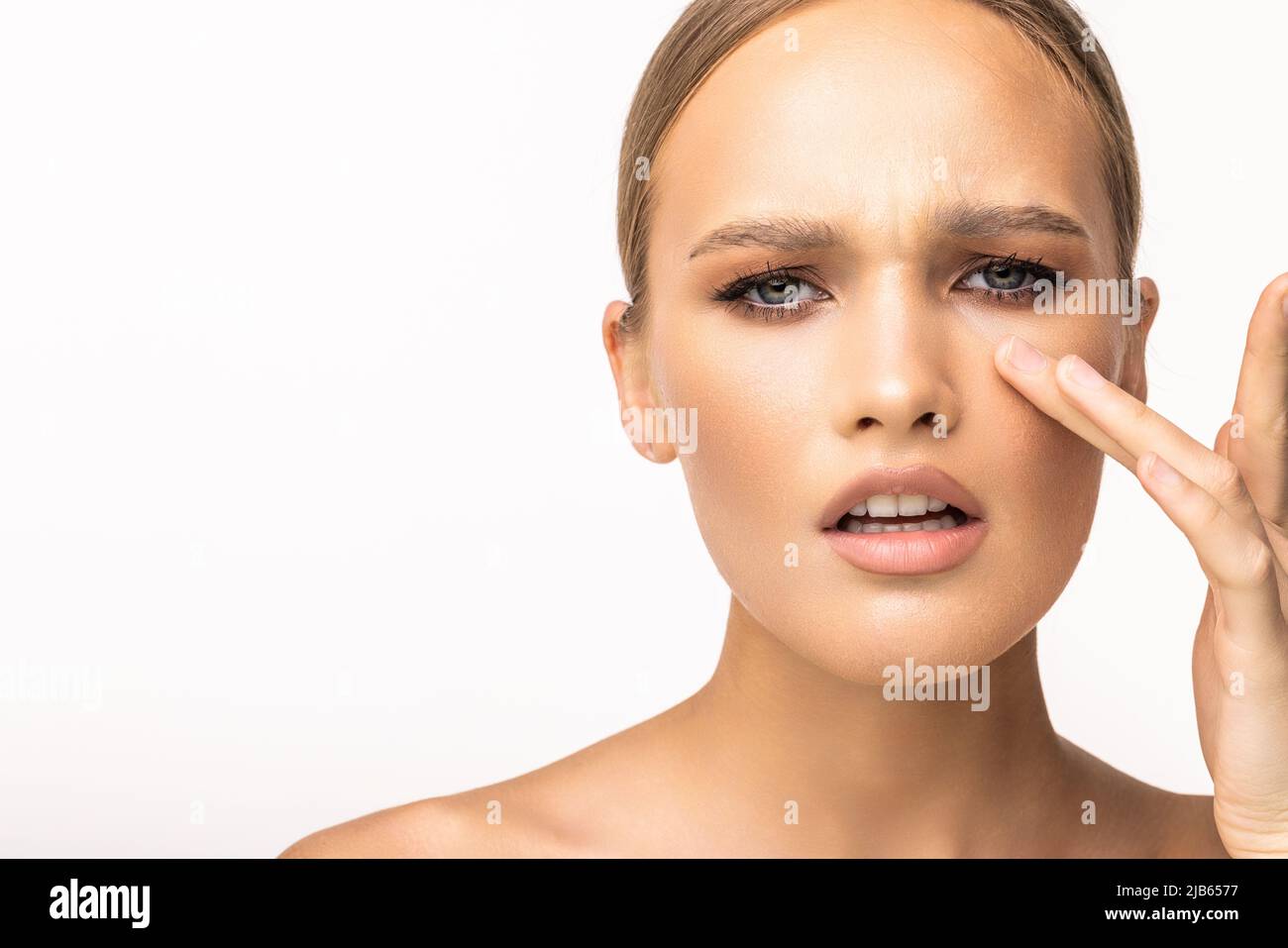 Beautiful Model Applying Cosmetic Cream Treatment On Her Face On White