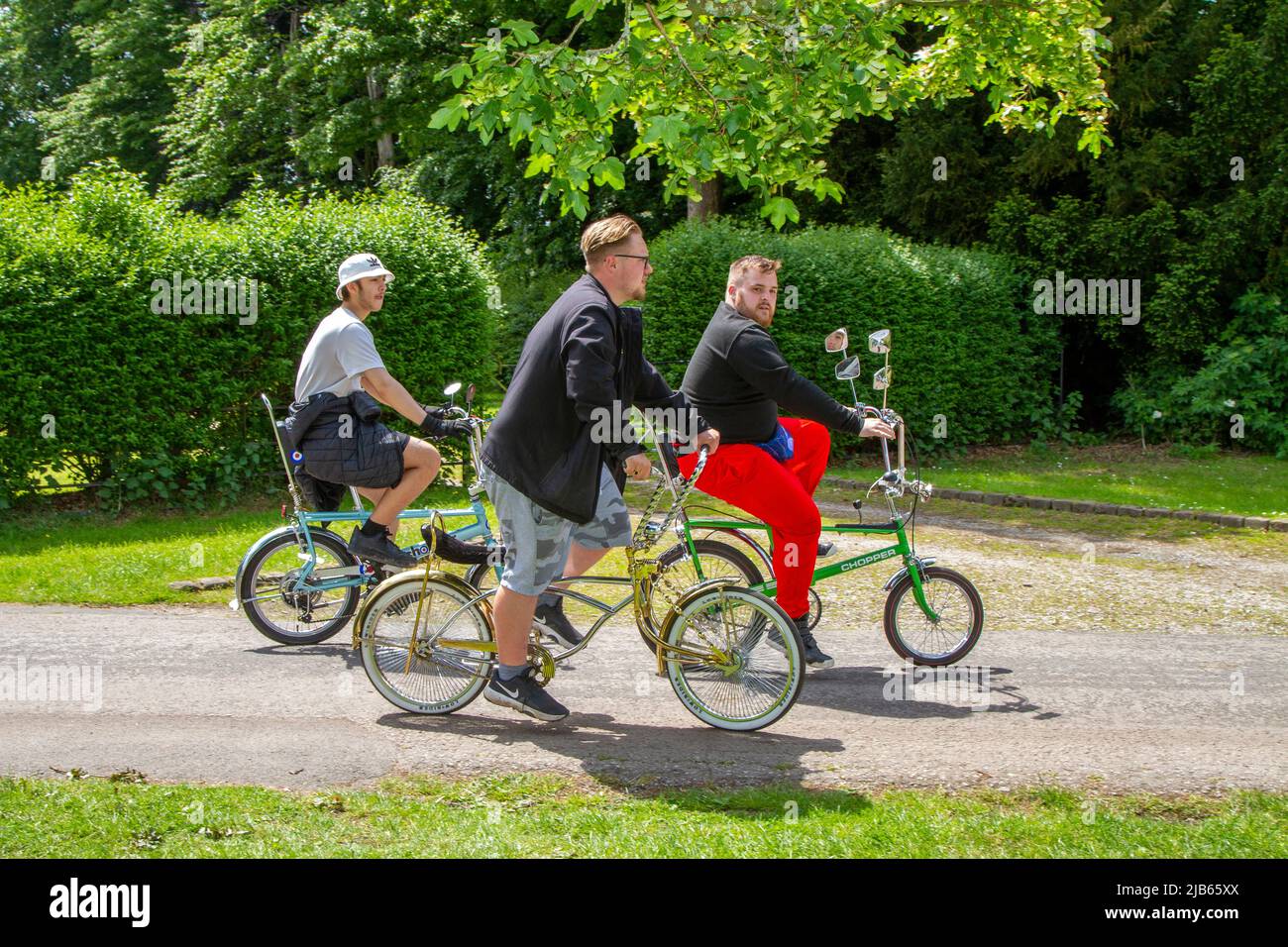 Three men riding small Chopper bicycles in Worden Park, Leyland, UK ...